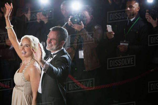 Celebrity couple waving to paparazzi at red carpet event - Royalty-free ...