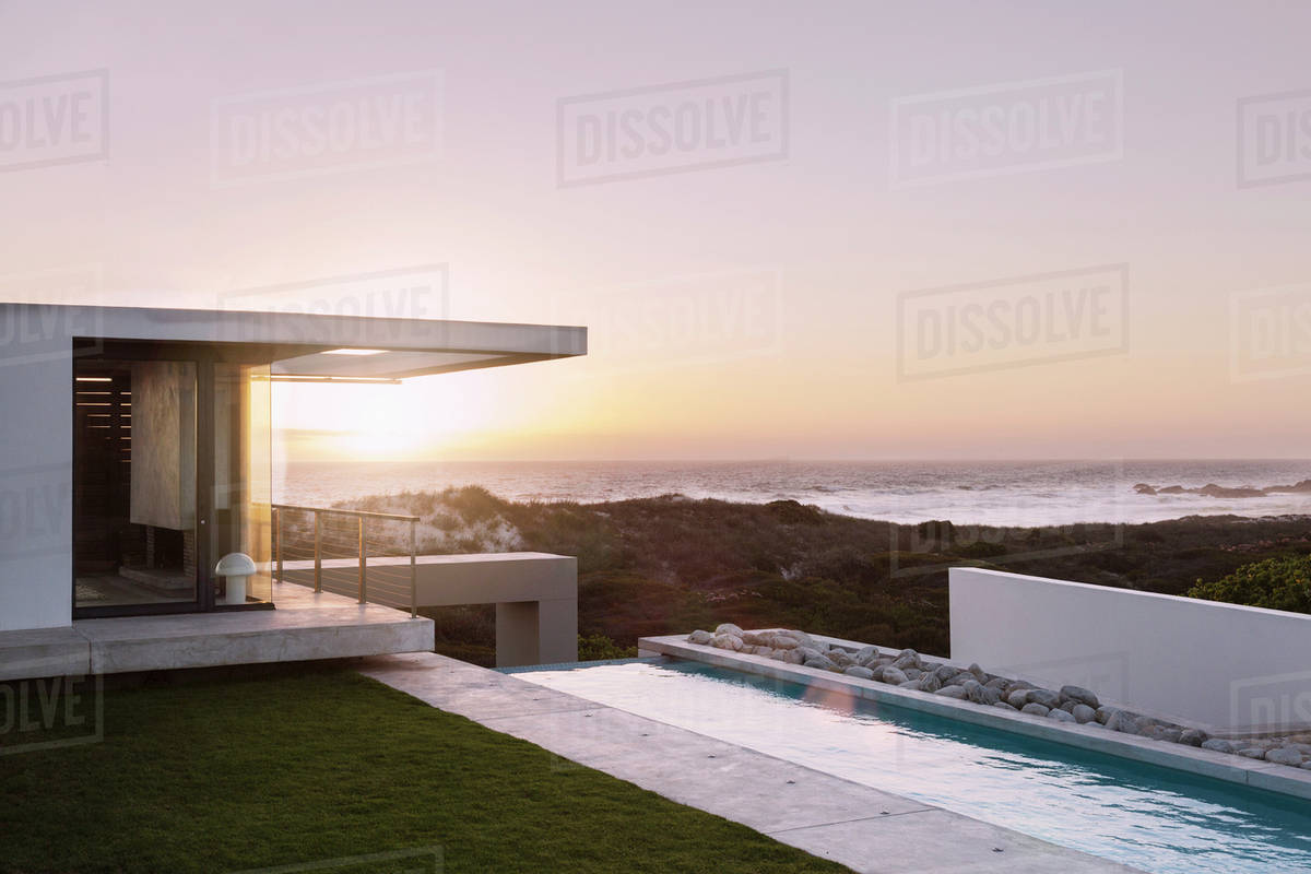 Modern house overlooking ocean at sunset - Stock Photo - Dissolve