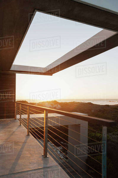 Balcony of modern house overlooking ocean at sunset - Royalty-free ...