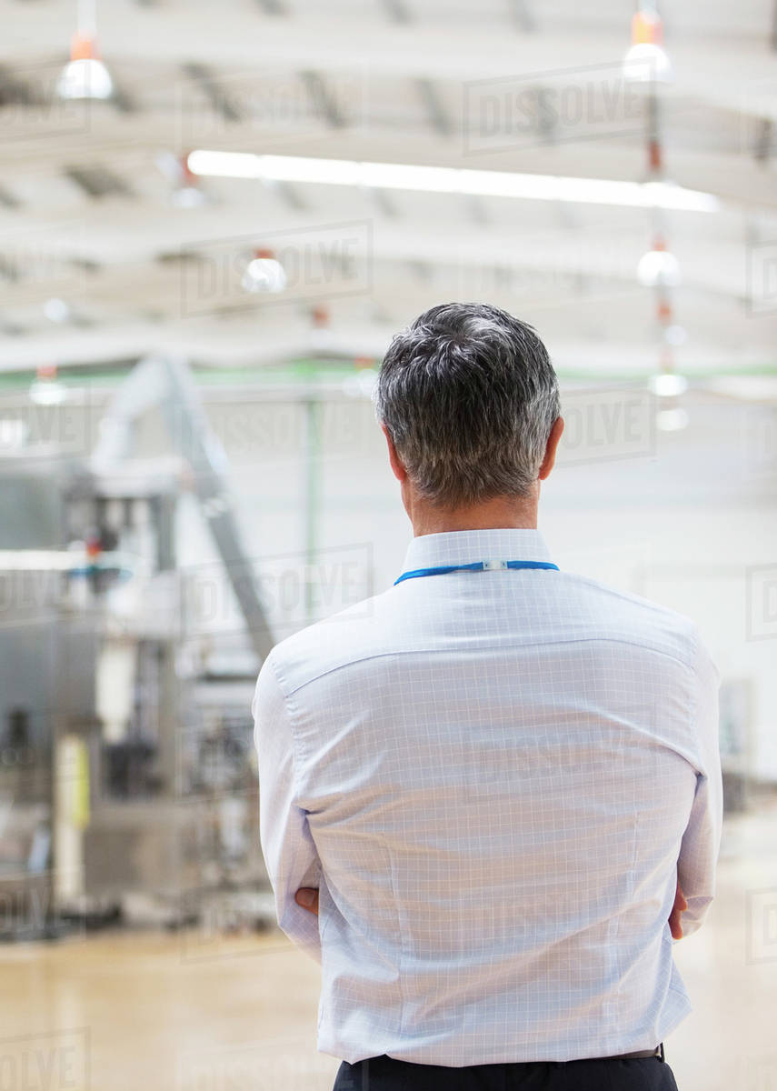 Businessman standing in factory - Stock Photo - Dissolve