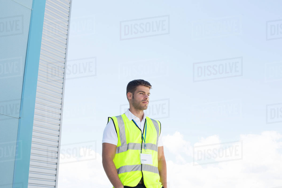 Worker standing below highrise building - Royalty-free Stock Photo ...
