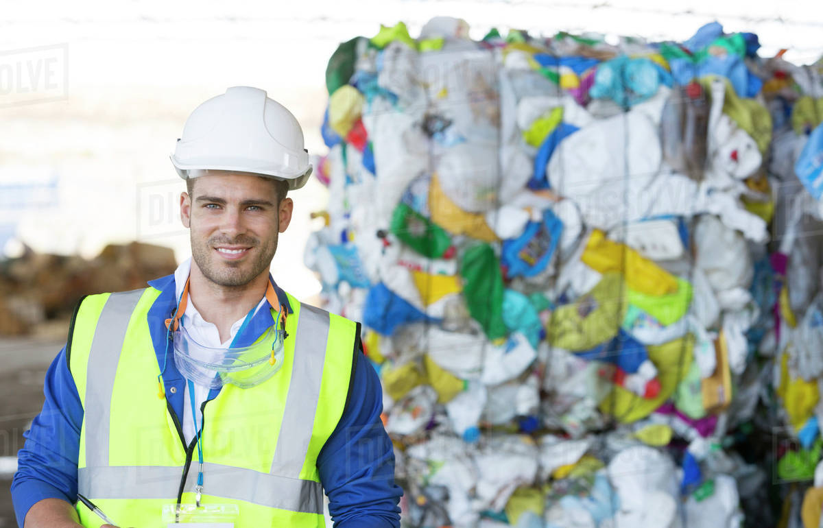 Worker smiling in recycling center - Royalty-free Stock Photo | Dissolve