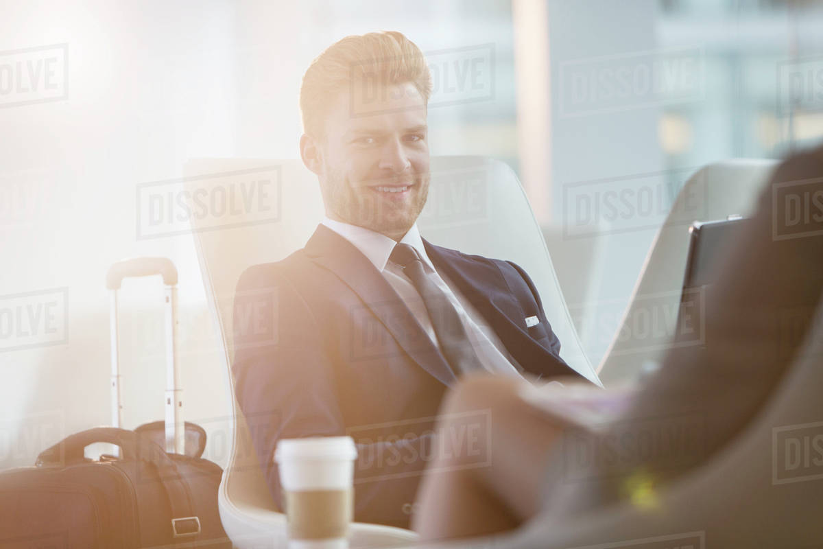 Businessman smiling in airport - Royalty-free Stock Photo | Dissolve