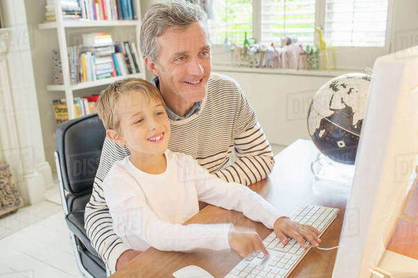 Father and son using computer together - Royalty-free Stock Photo ...