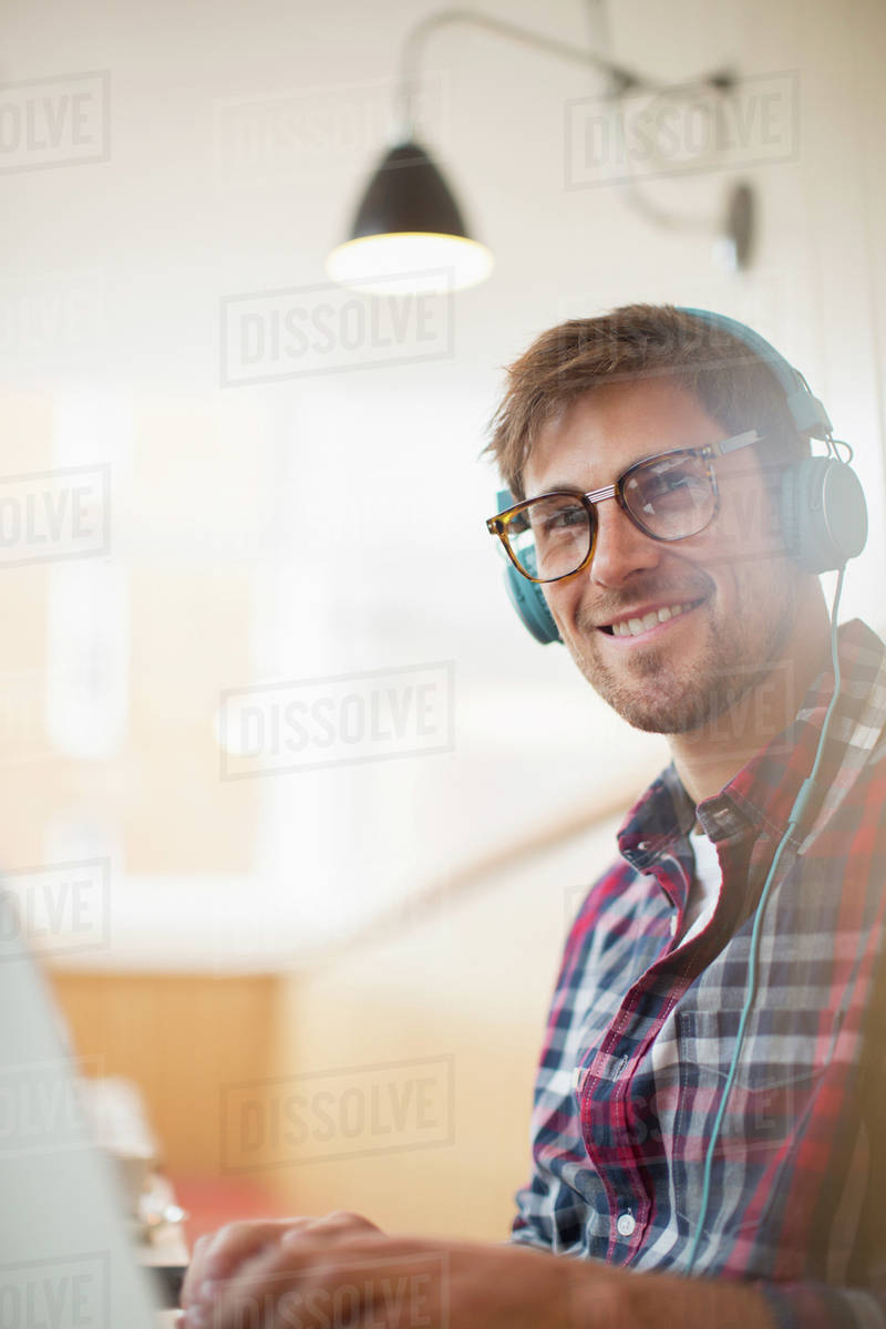 Man wearing headphones and using laptop - Royalty-free Stock Photo ...