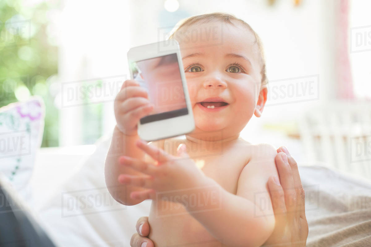 Baby boy playing with cell phone - Royalty-free Stock Photo | Dissolve