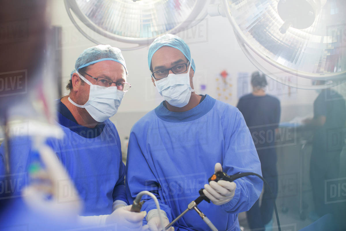 Portrait of doctors performing laparoscopic surgery in operating ...