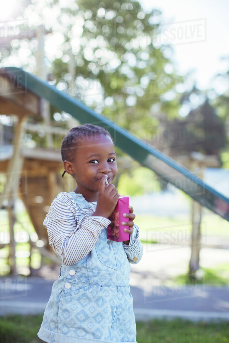 Girl drinking juice box at playground - Royalty-free Stock Photo | Dissolve