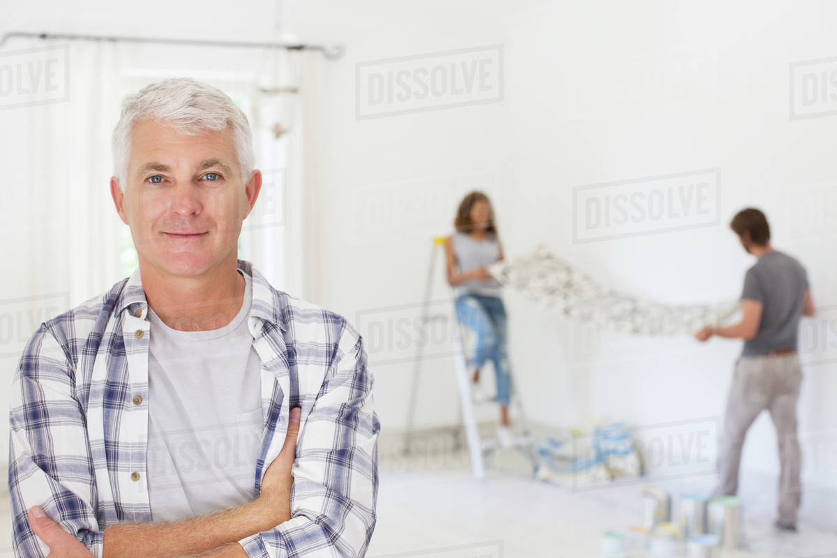 Older man smiling with family working - Royalty-free Stock Photo | Dissolve