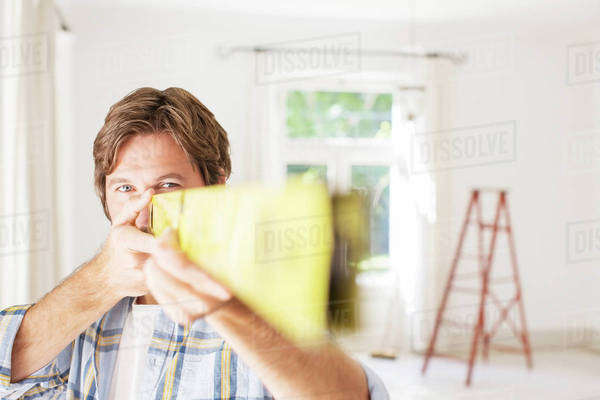 Man holding wood close to face - Royalty-free Stock Photo | Dissolve