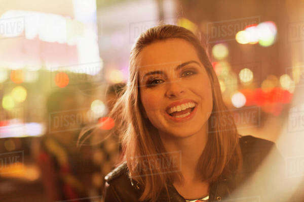 Woman smiling on city street at night - Royalty-free Stock Photo | Dissolve