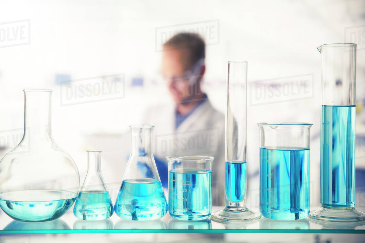 Close up of various solutions in beakers on shelf in lab - Royalty-free ...