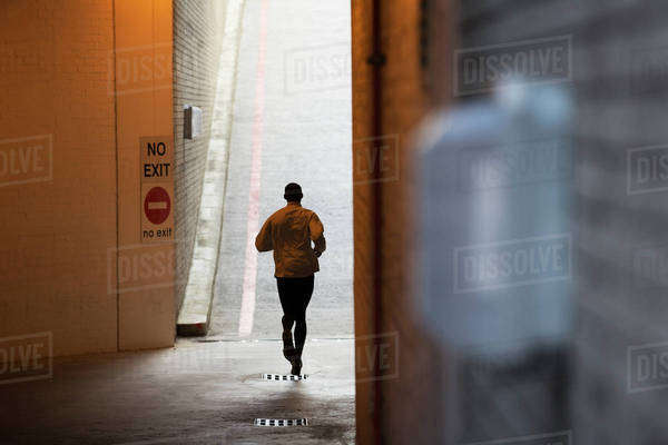 Man running through city streets - Royalty-free Stock Photo | Dissolve
