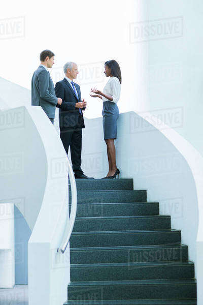 Business people talking on stairs of office building - Royalty-free ...