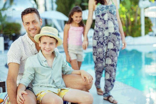 Family enjoying themselves by swimming pool - Royalty-free Stock Photo ...