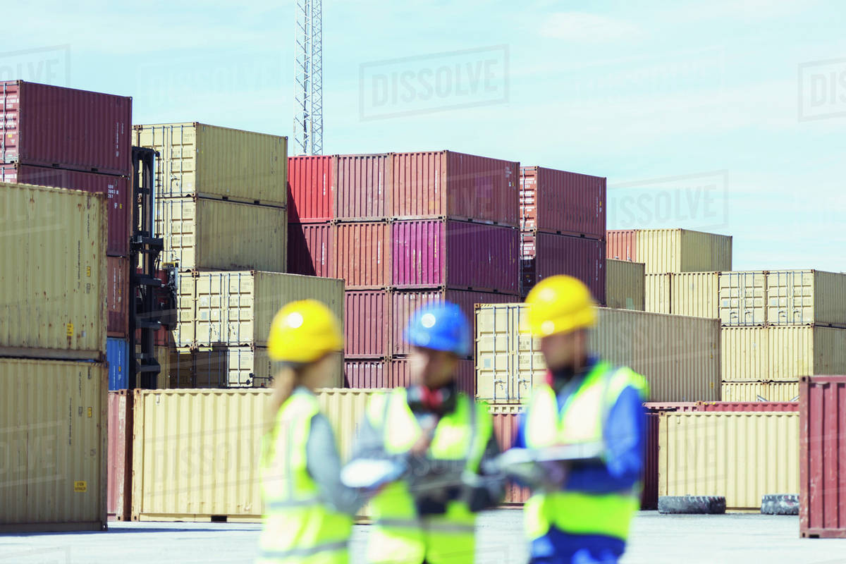 Businessman and workers talking near cargo containers - Royalty-free ...