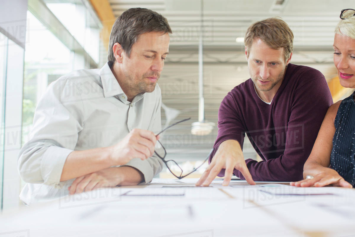 Business people reading paperwork in office meeting - Royalty-free ...