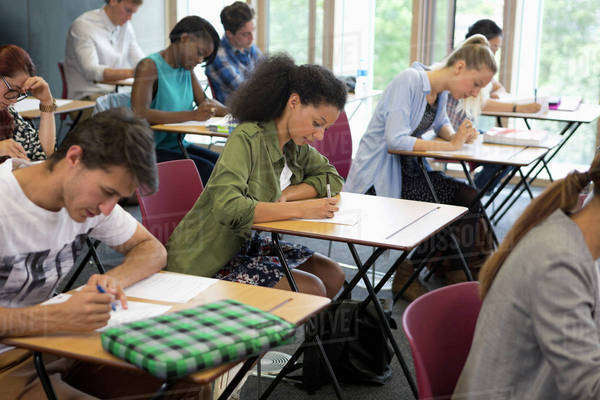 University students taking exam in classroom - Stock Photo - Dissolve