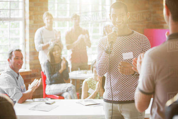 Audience clapping for smiling speaker - Stock Photo - Dissolve