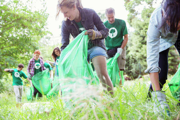 Environmentalist volunteers picking up trash in field - Royalty-free ...