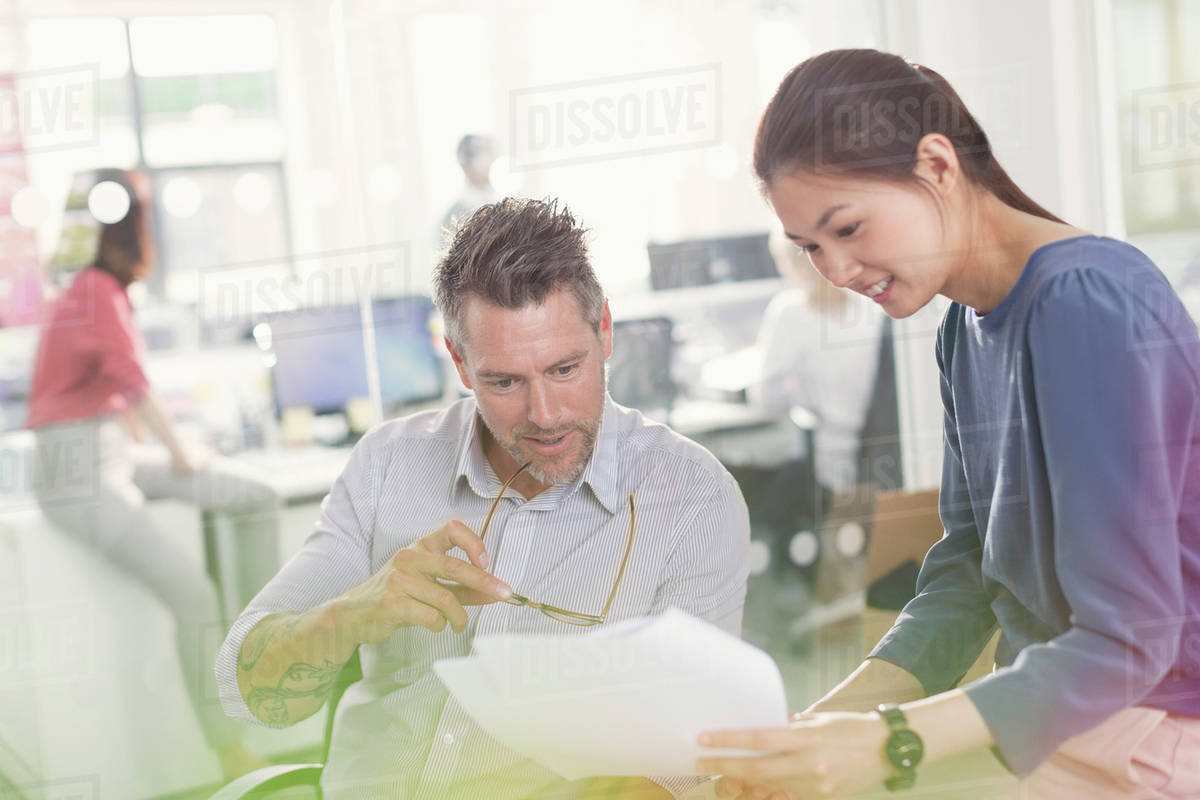 Business people reviewing paperwork in office - Royalty-free Stock ...