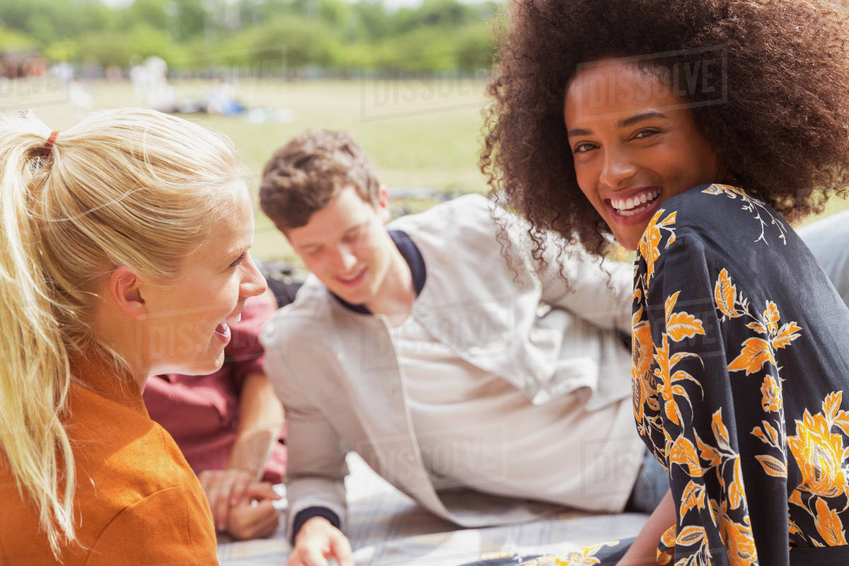 Portrait smiling woman hanging out with friends in sunny park - Royalty ...