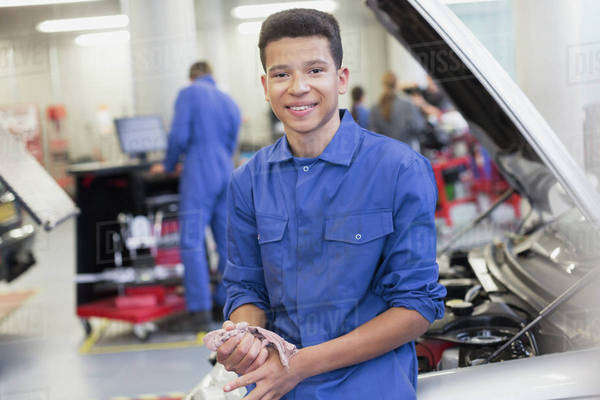 Portrait smiling mechanic leaning on car in auto repair shop - Royalty ...