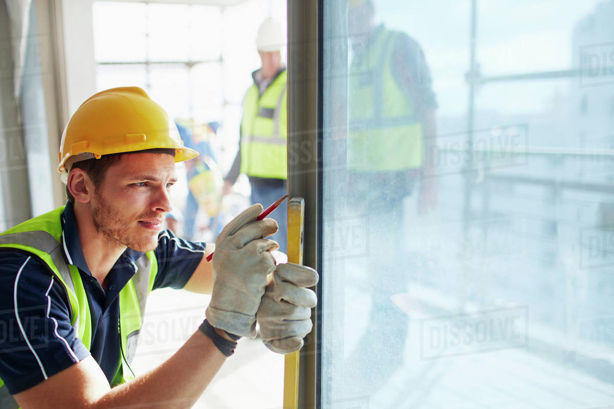 Construction worker measuring window at construction site - Stock Photo ...