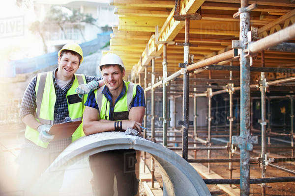 Portrait confident engineers with clipboard at construction site ...