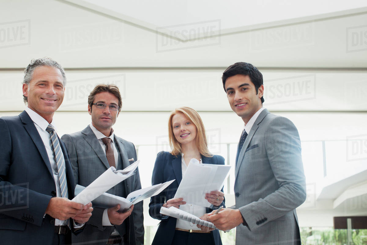 Portrait of smiling business people reviewing paperwork - Royalty-free ...