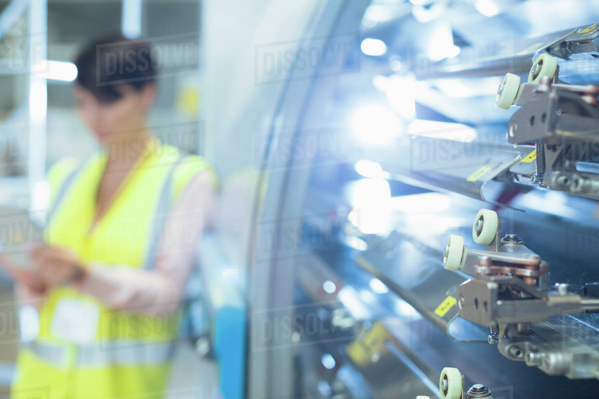 Worker behind machinery in factory - Stock Photo - Dissolve