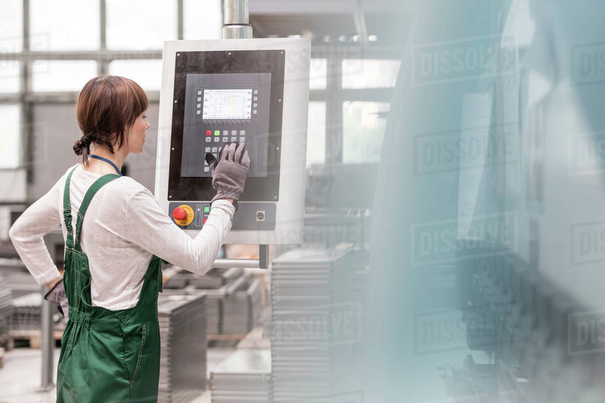 Worker at control panel operating machinery in factory - Royalty-free ...