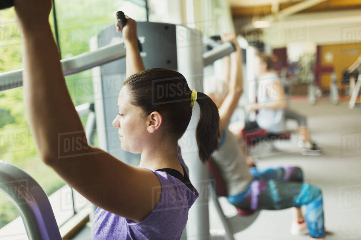 Focused woman using exercise equipment at gym - Royalty-free Stock ...