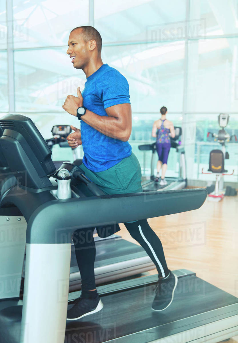 Man running on treadmill at gym - Royalty-free Stock Photo | Dissolve