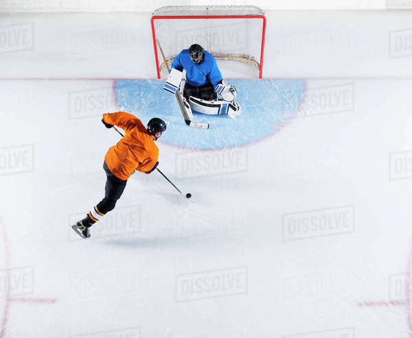 Hockey player shooting the puck at goal net - Royalty-free Stock Photo ...
