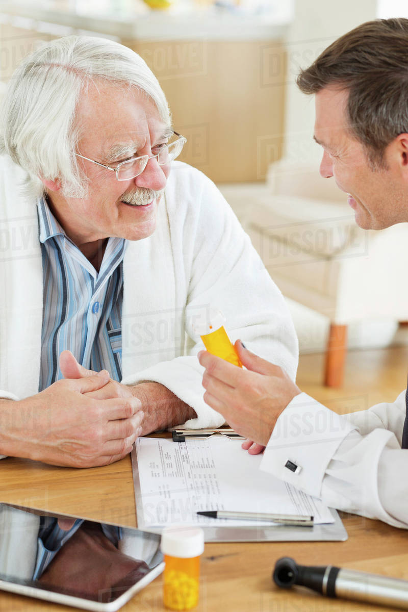 Doctor giving medication to older patient at house call - Stock Photo ...