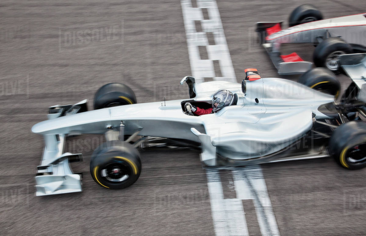 Race car crossing finish line on track - Stock Photo - Dissolve