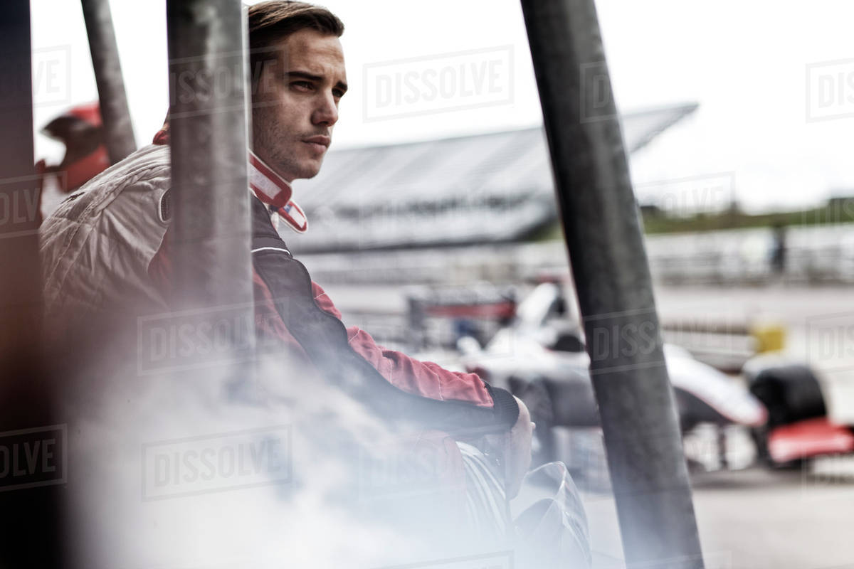 Racer standing on sidelines on track - Royalty-free Stock Photo | Dissolve