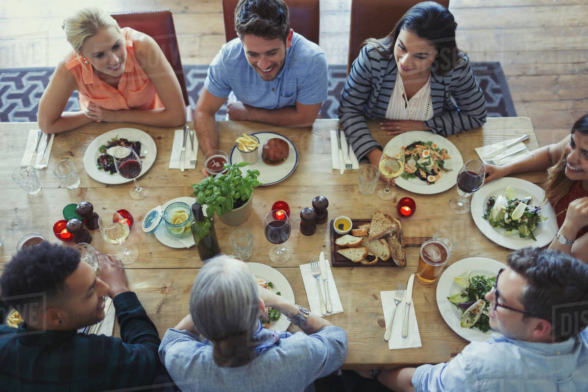 Overhead view friends talking and dining at restaurant table - Stock ...