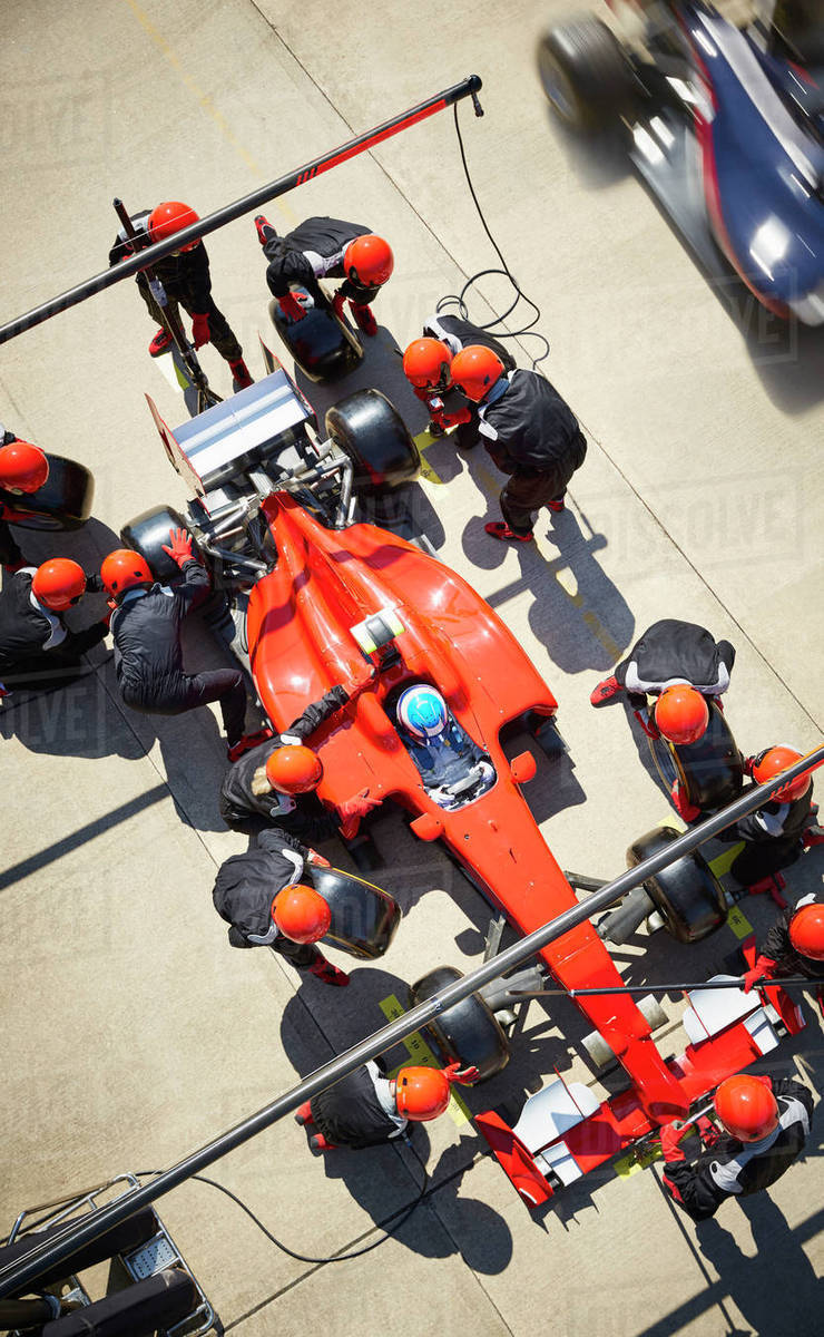 Overhead pit crew working on formula one race car in pit lane - Royalty ...