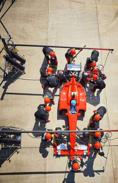Overhead pit crew working on formula one race car in pit lane - Royalty ...