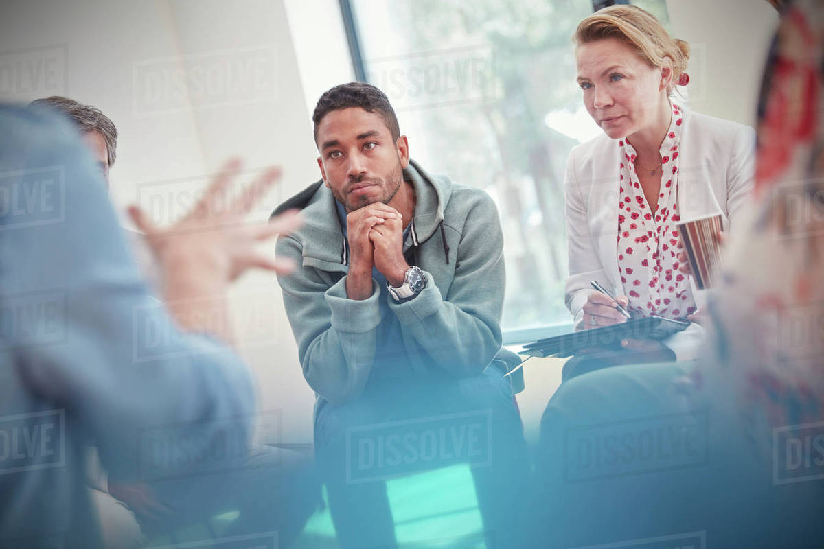 Attentive man and woman listening in group therapy session - Royalty ...
