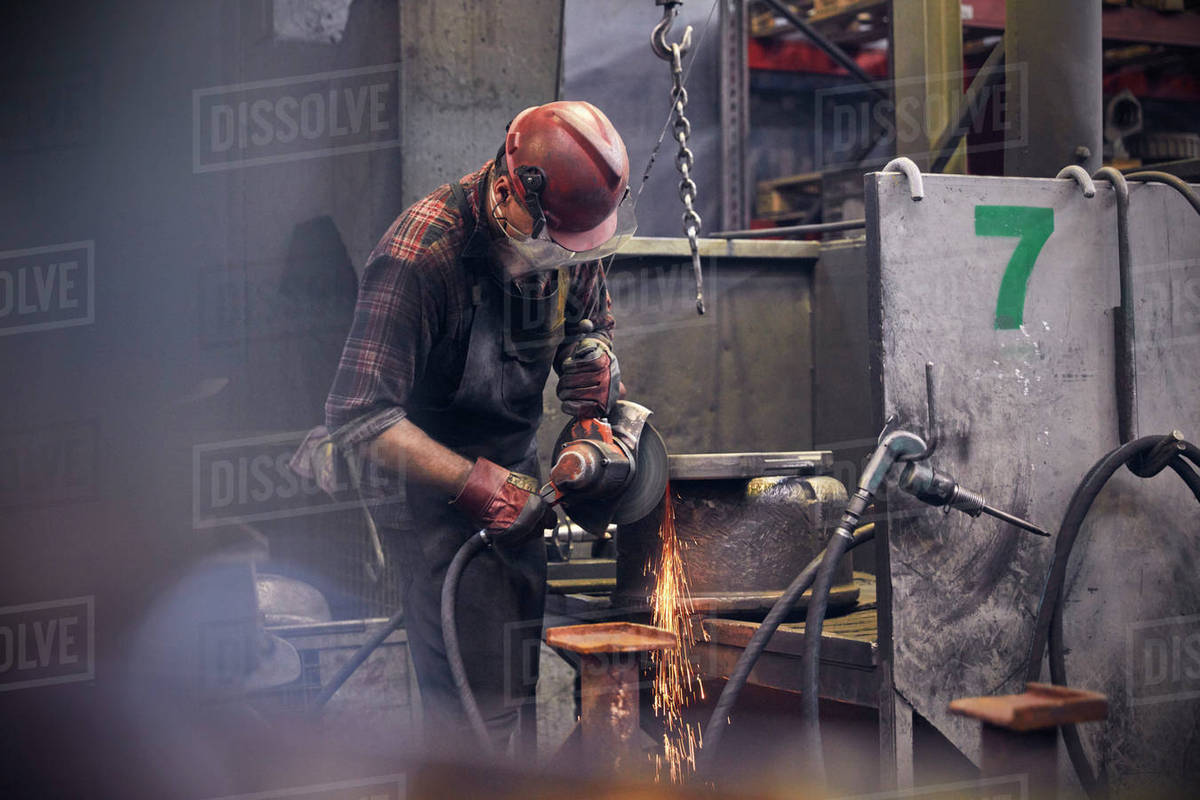 Steelworker using lathe in steel mill - Royalty-free Stock Photo | Dissolve
