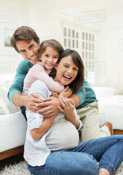 Family hugging in living room - Royalty-free Stock Photo | Dissolve