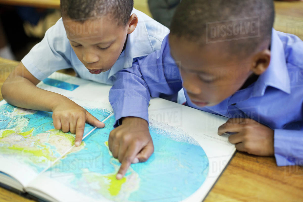 Students using world map in class - Stock Photo - Dissolve