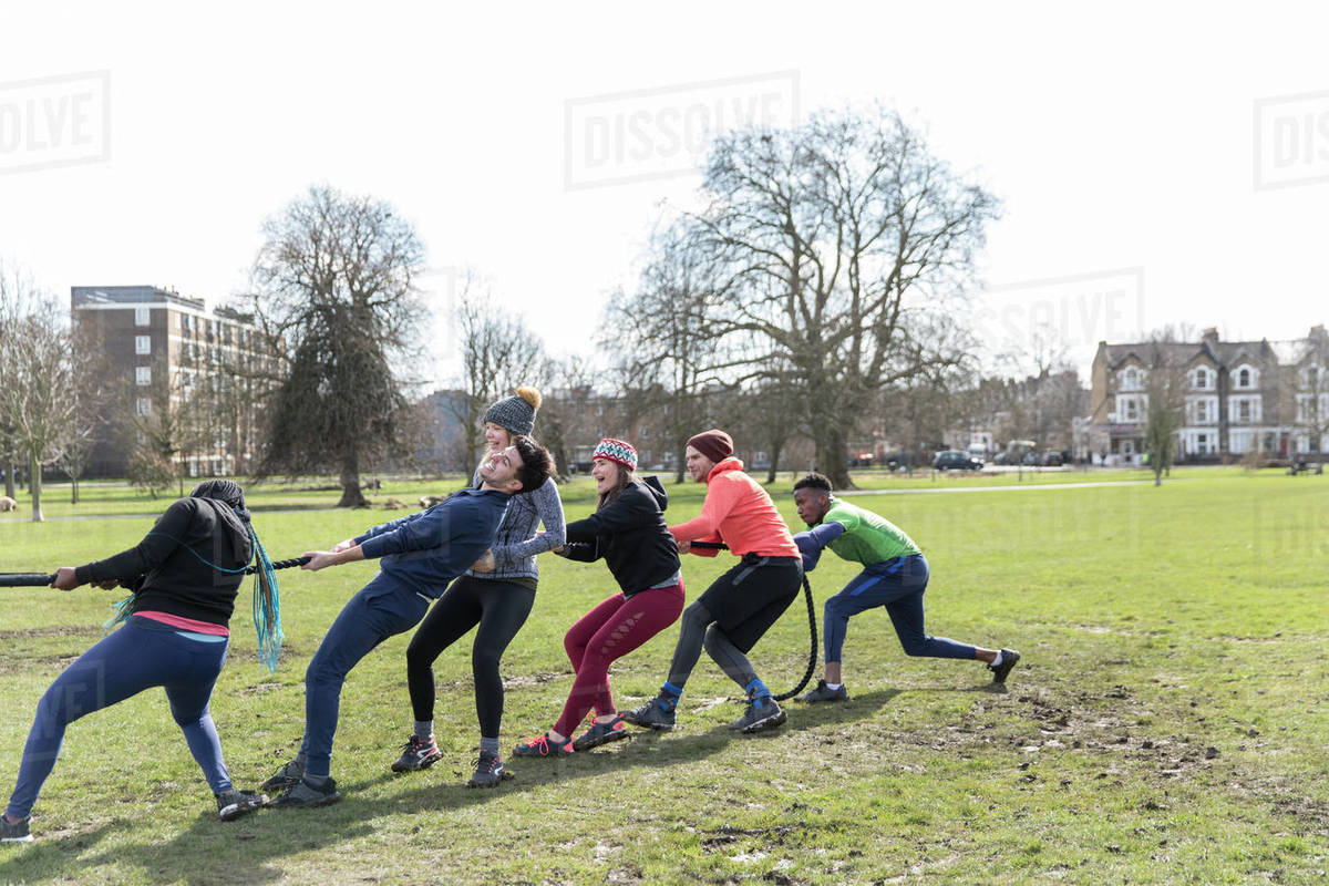Determined team pulling rope in tug-of-war in park - Royalty-free Stock ...