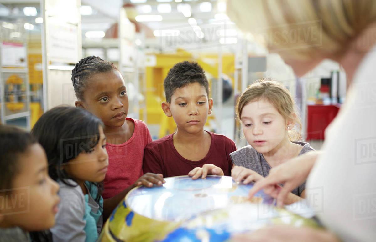 Teacher and curious students at interactive earth exhibit in science ...