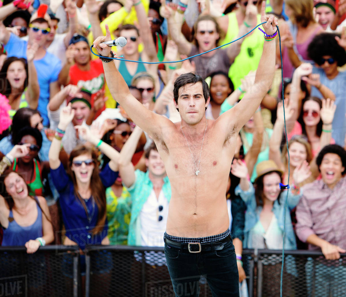 Fans cheering behind performer on stage at music festival - Royalty ...