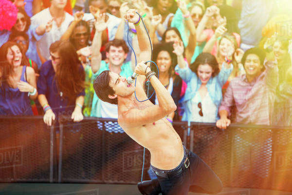 Fans cheering for performer singing on stage - Stock Photo - Dissolve