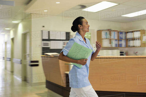 Nurse rushing in hospital hallway - Stock Photo - Dissolve